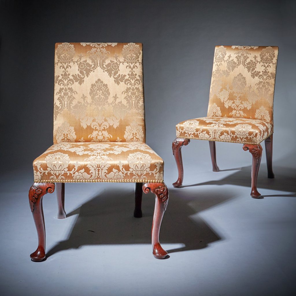 A Pair of George II Mahogany High Back Chairs on Carved Cabriole Legs
